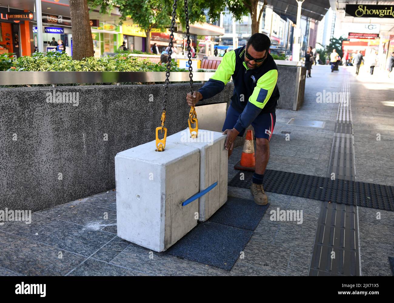 Workers install concrete bollards at the entrance to Queen Street mall ...