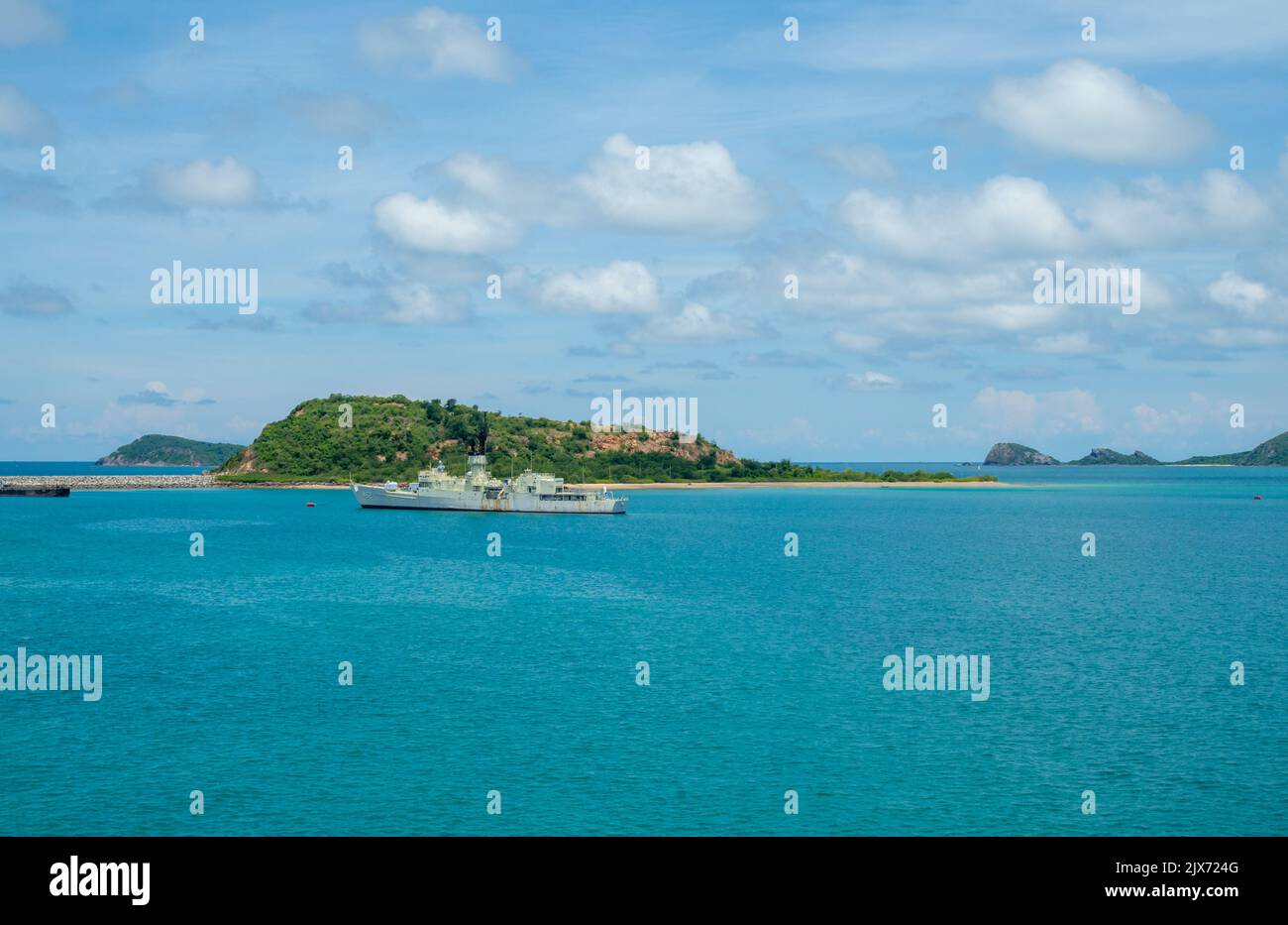Military warships are stationary beside a small island. against a ...