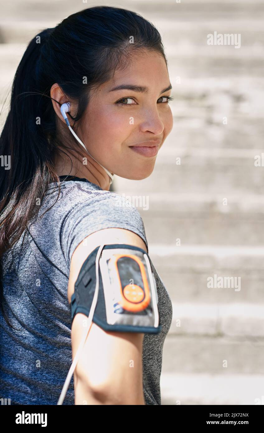 Lets do this. a sporty young woman listening to music while exercising ...