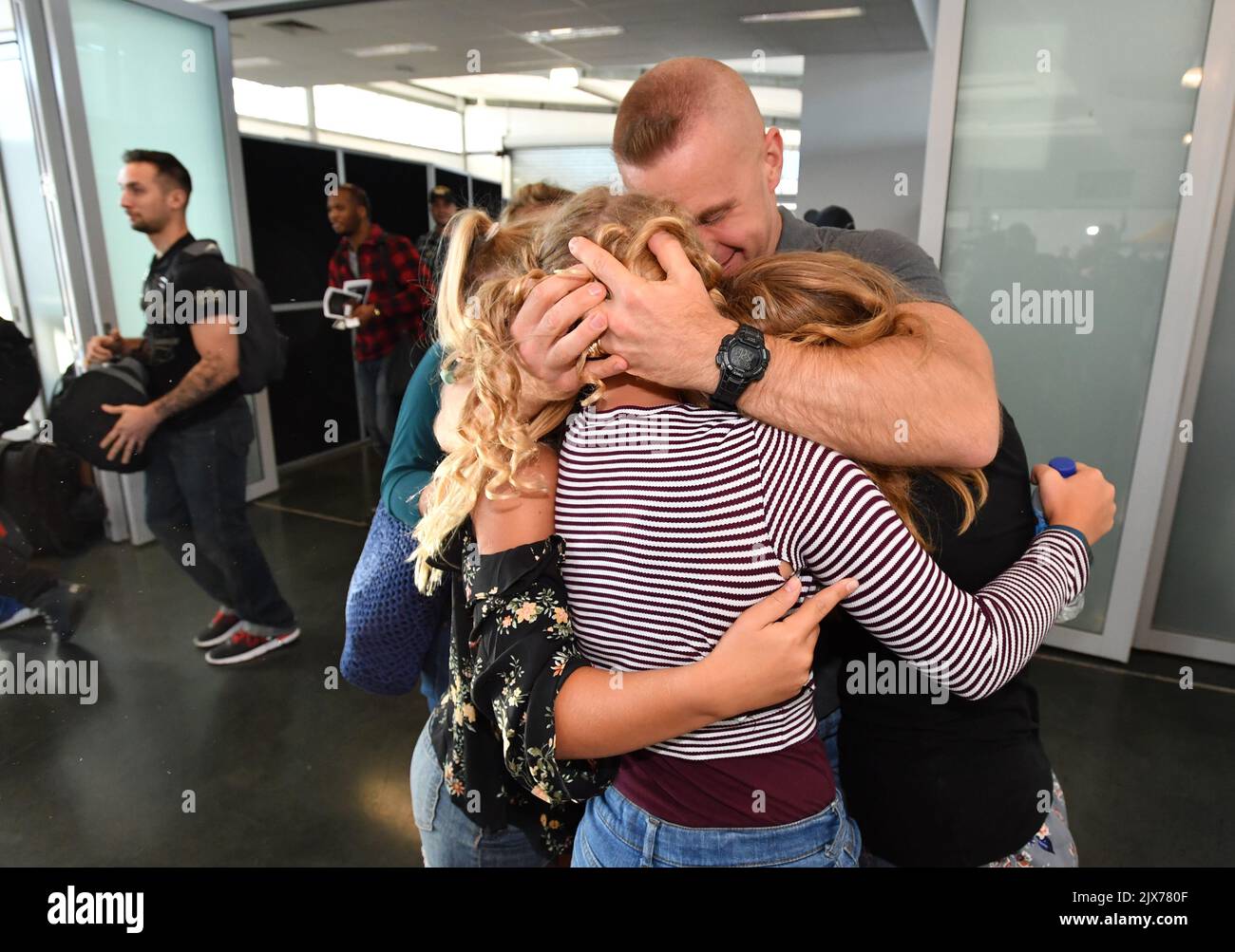 Commander Shane Tanner hugs his family after he arrived on the USS ...