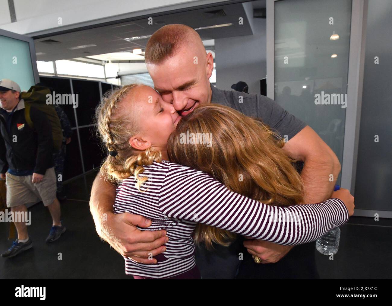 Commander Shane Tanner hugs his family after he arrived on the USS ...