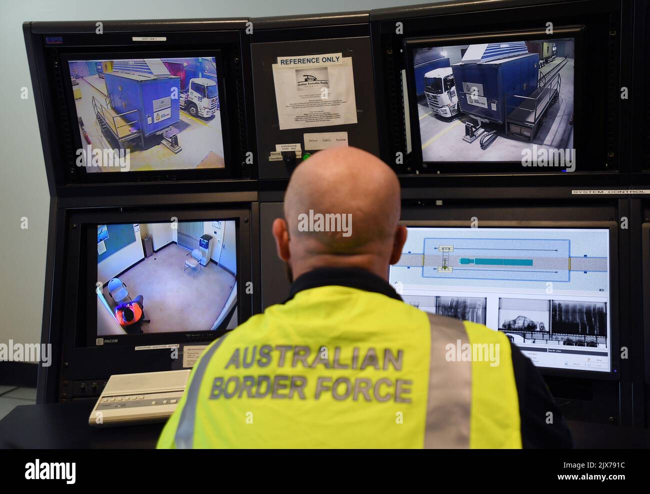 An Australian Border Force official looks at screens at the system ...