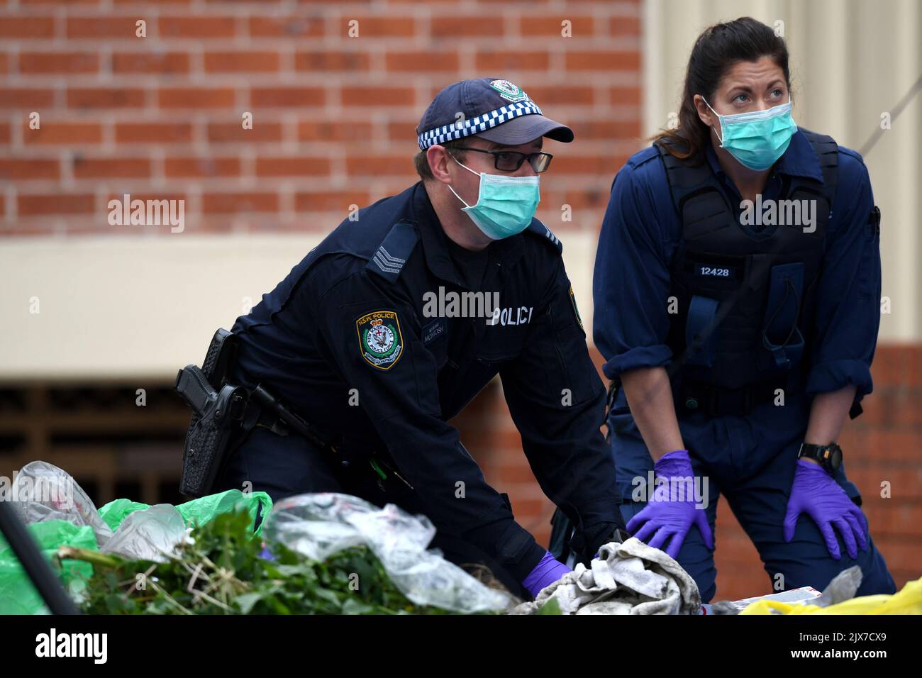 Police officers search items from a property in relation to counter ...