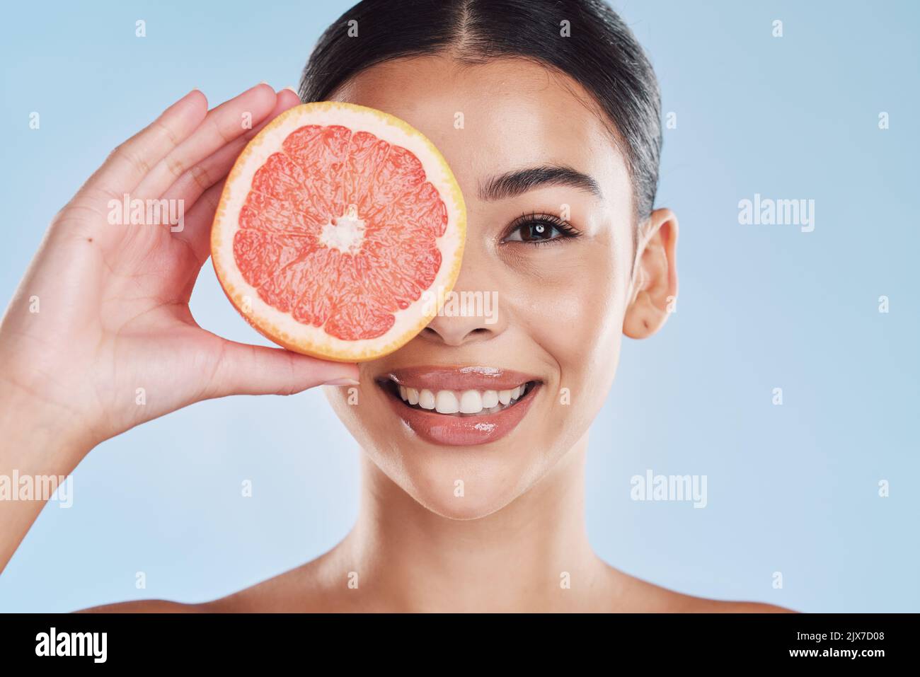 Portrait of woman with happy face and grapefruit in blue studio ...