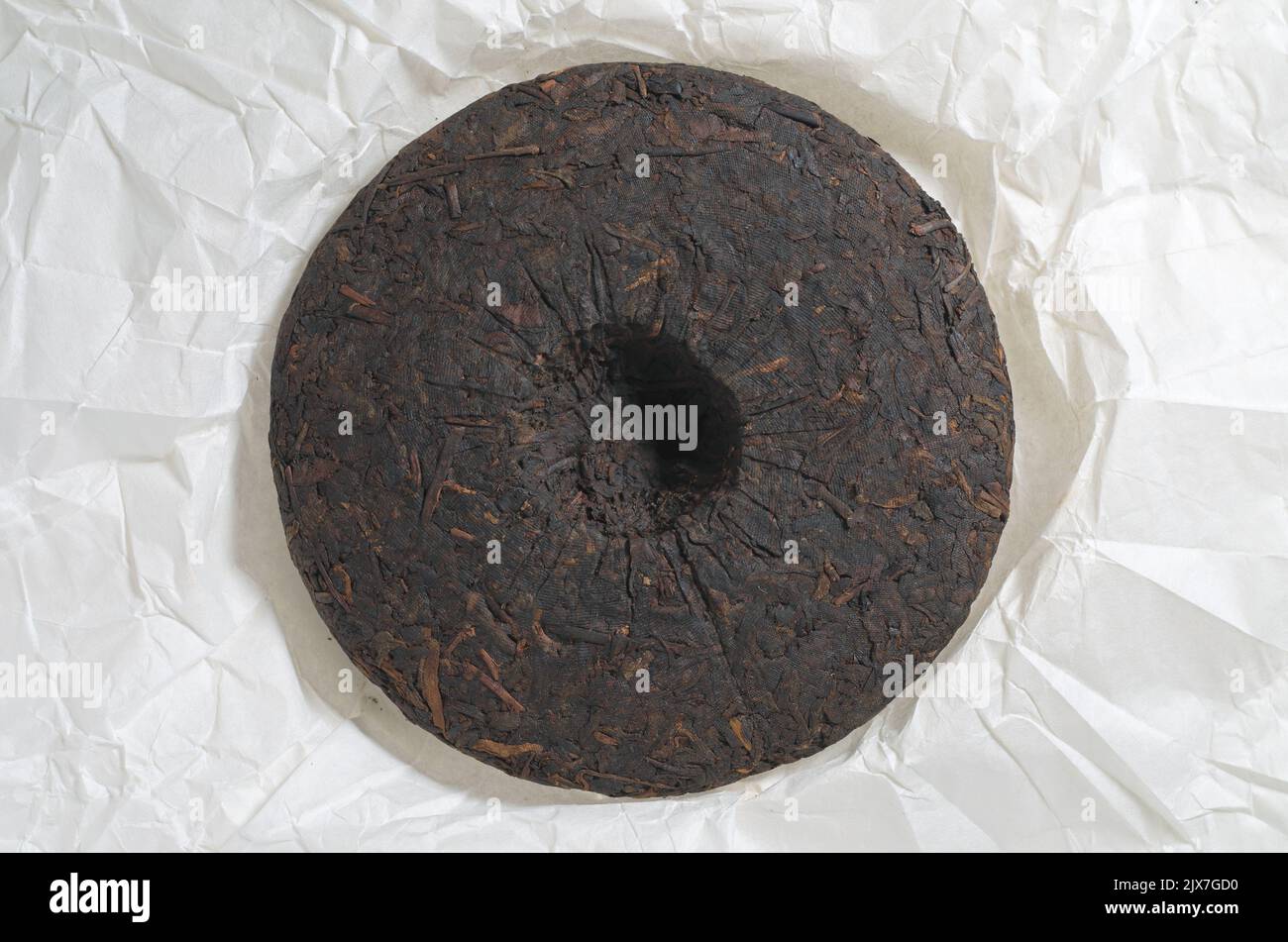 Pressed pu-erh tea on the background of rice paper, top view ...