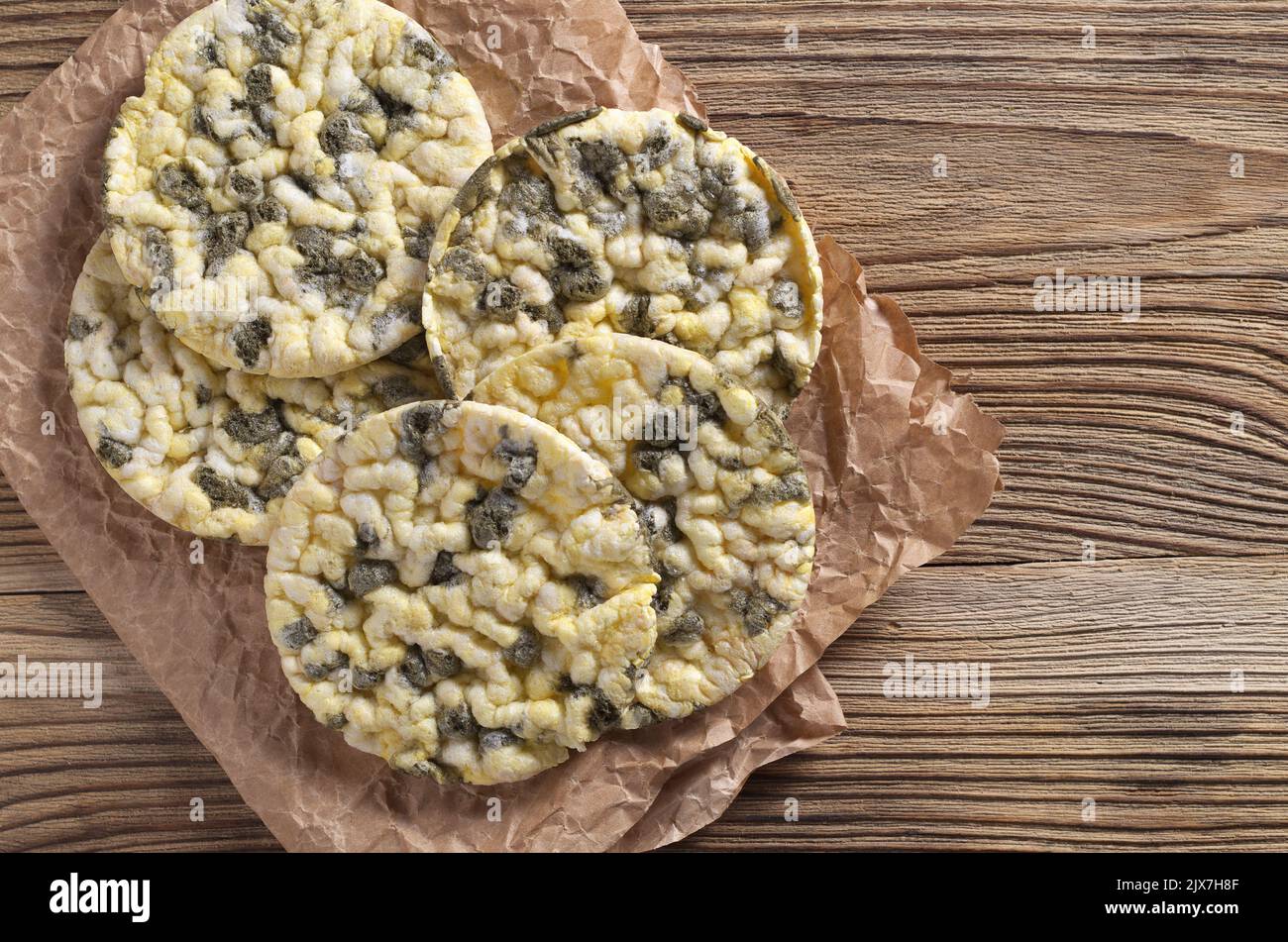 Puffed rice cakes on crumpled paper located on wooden background, top ...