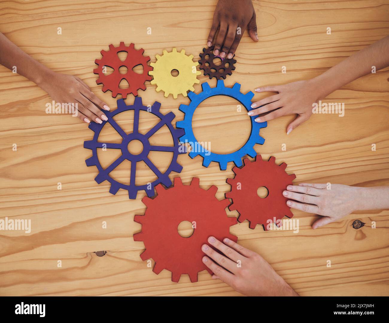 Hands, gears and collaboration with a team of people working with cogs ...