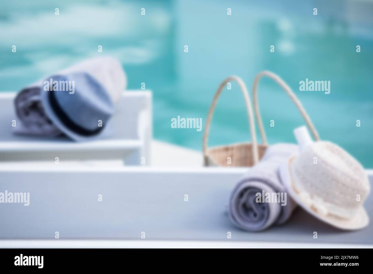 Hats and towels on tables against swimming pool Stock Photo - Alamy