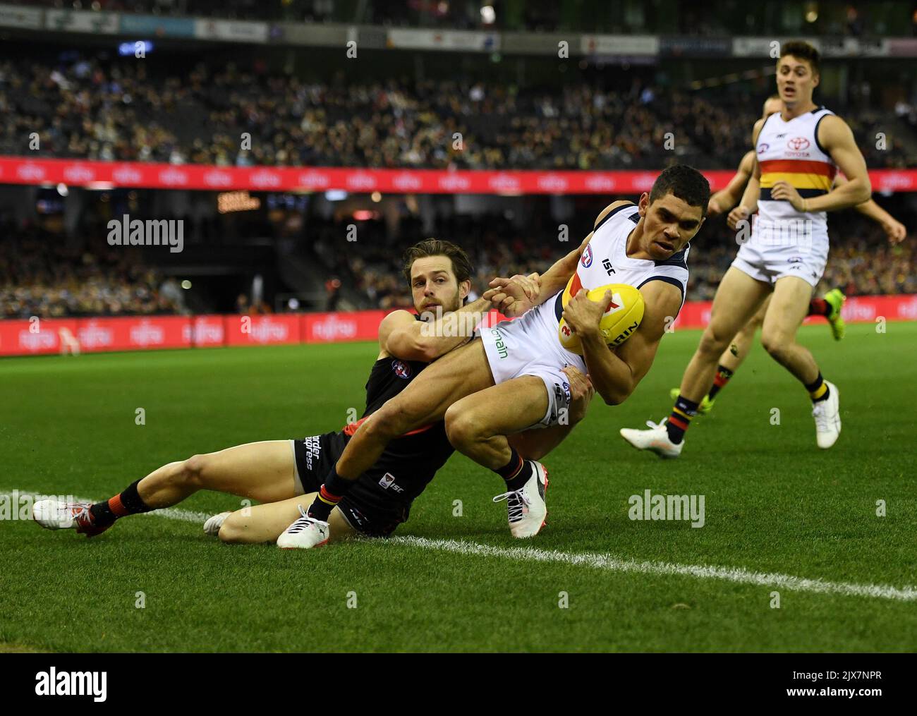 Charlie Cameron of the Crows is tackled by Travis Colyer of the Bombers ...