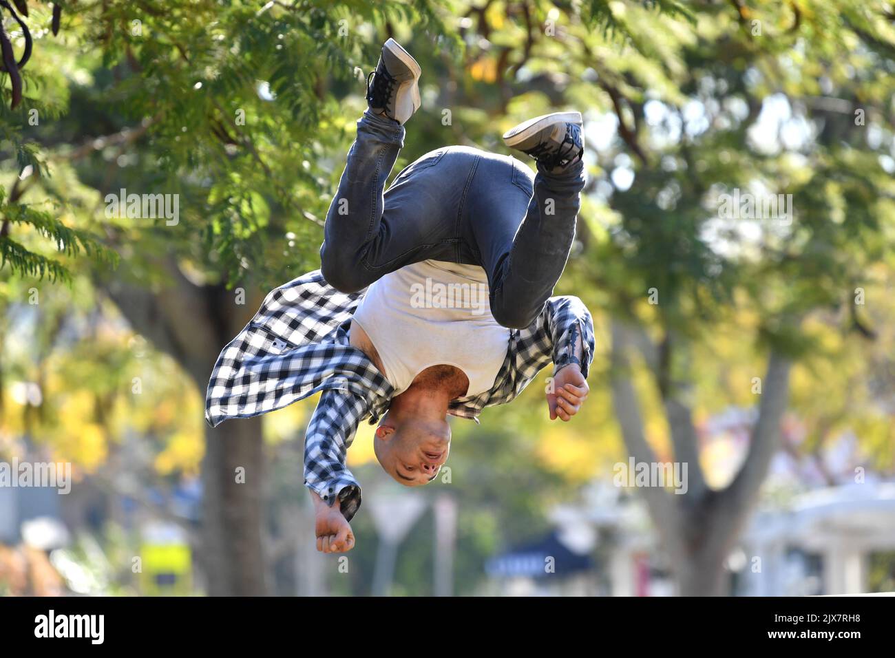 Simon Hawker performs tricks on a Slackline in New Farm Park in ...