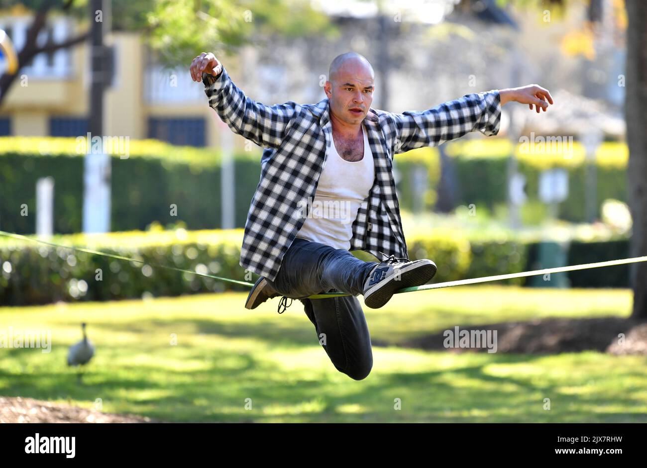 Simon Hawker performs tricks on a Slackline in New Farm Park in ...