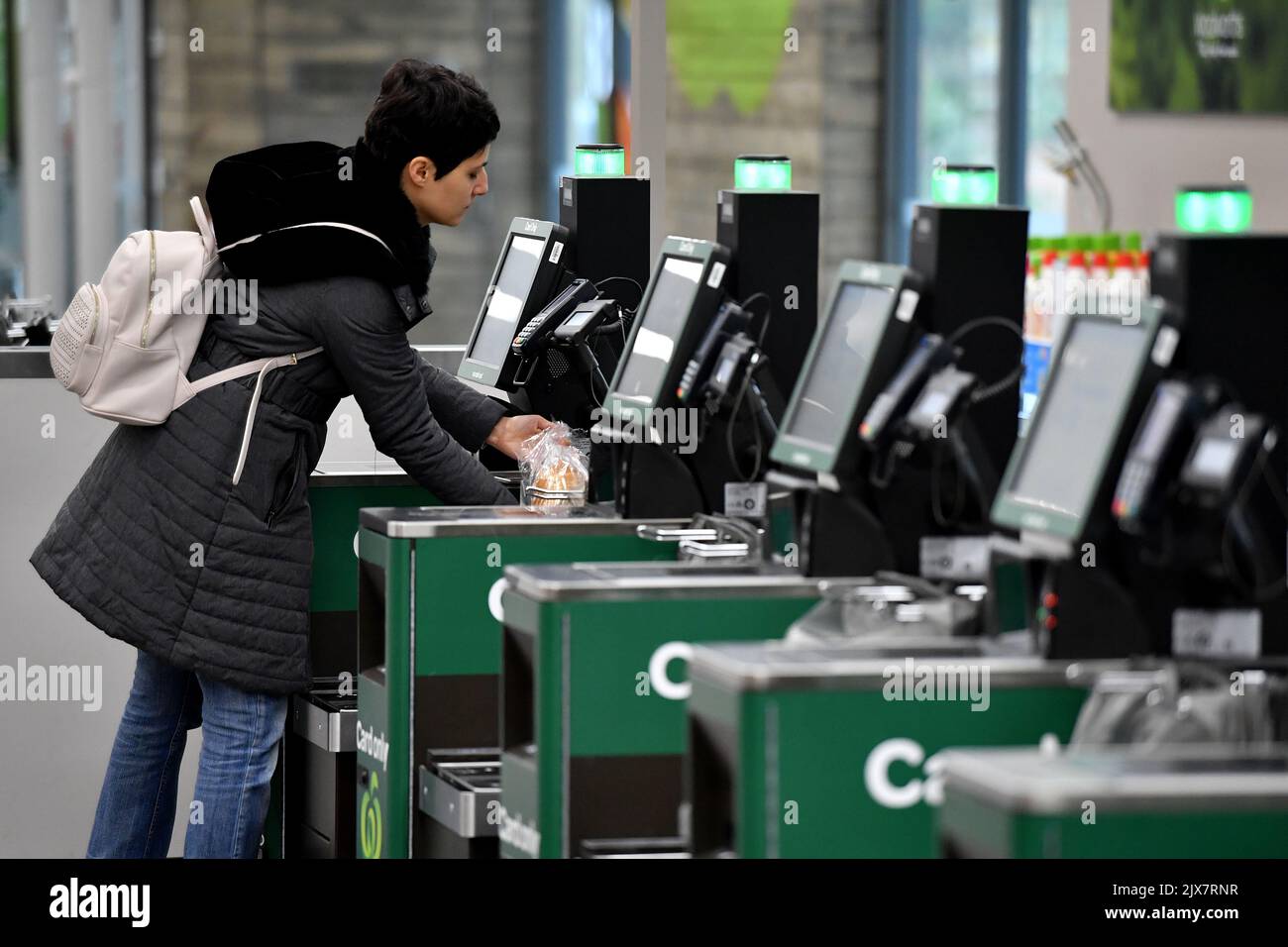 A woman uses a self service checkouts at a Woolworths store in Sydney ...