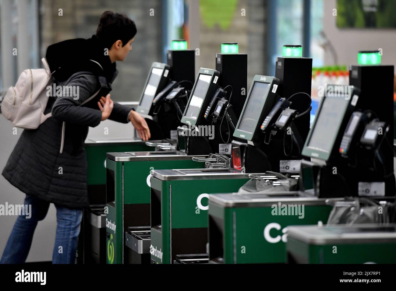 A woman uses a self service checkouts at a Woolworths store in Sydney ...