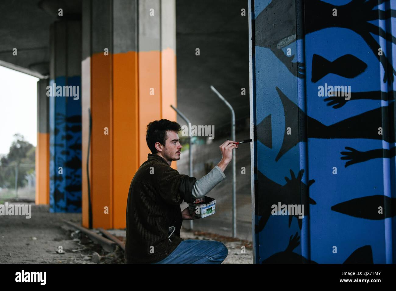 Artist Nick Rix is seen painting a mural underneath railway bridge on ...