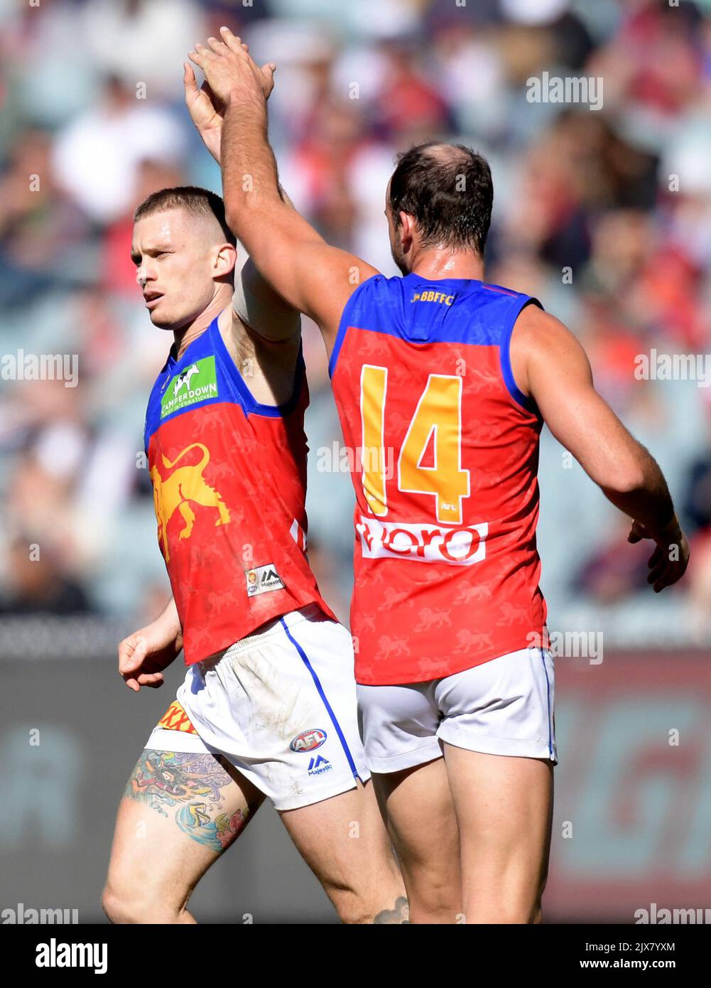 Dayne Beams of the Lions celebrates a goal with Josh Walker of the ...