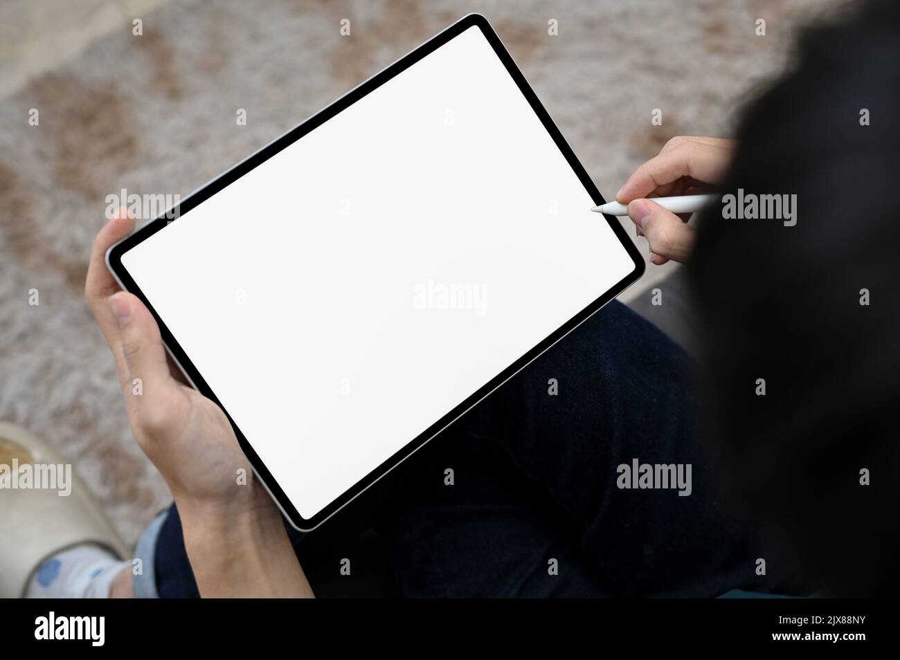 Overhead view, A man relaxing in living room, using digital tablet ...