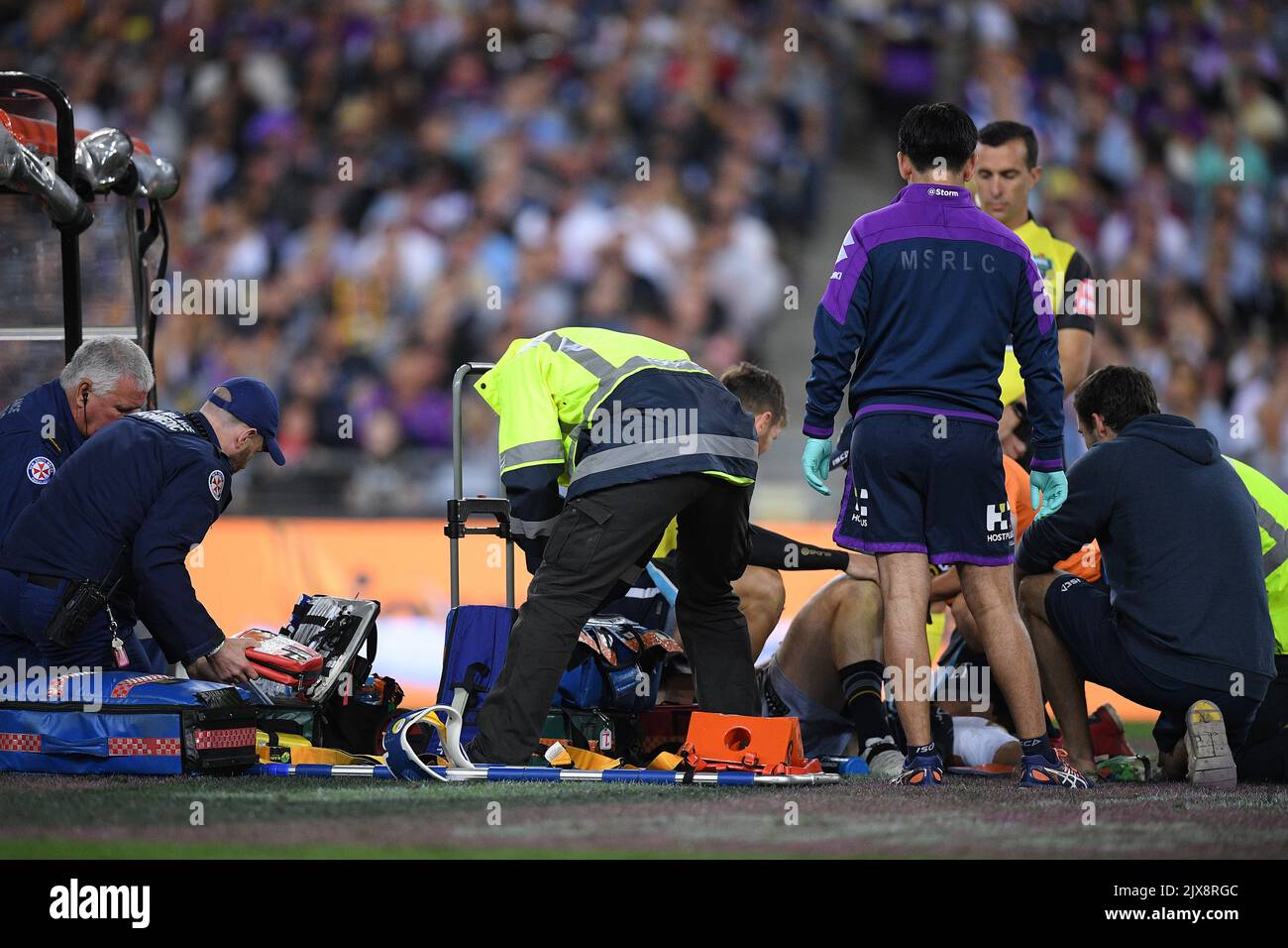 Shaun Fensom of the Cowboys is assisted by trainers during the NRL ...