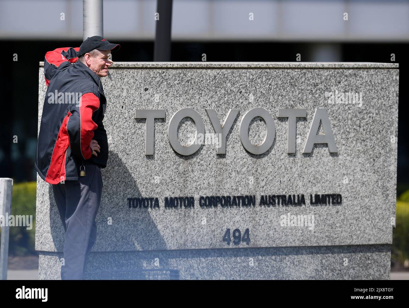 A Toyota staff member poses for photographs with the sign at the Toyota ...