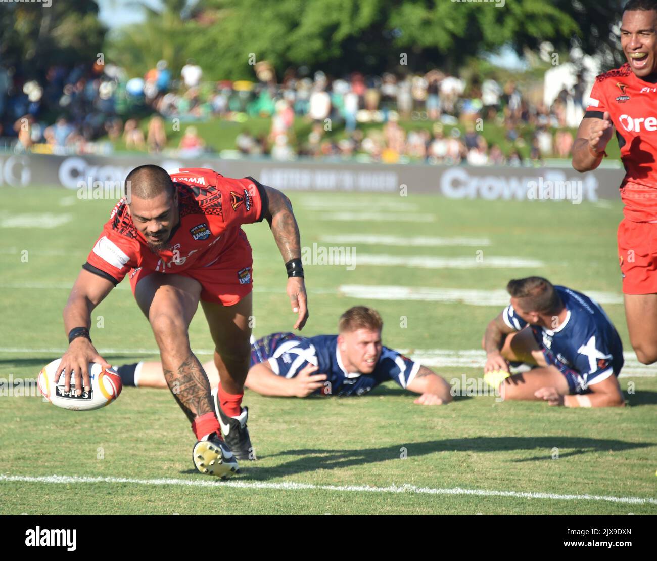 Tonga's Sika Manu powers through two Scottish defenders to score his ...
