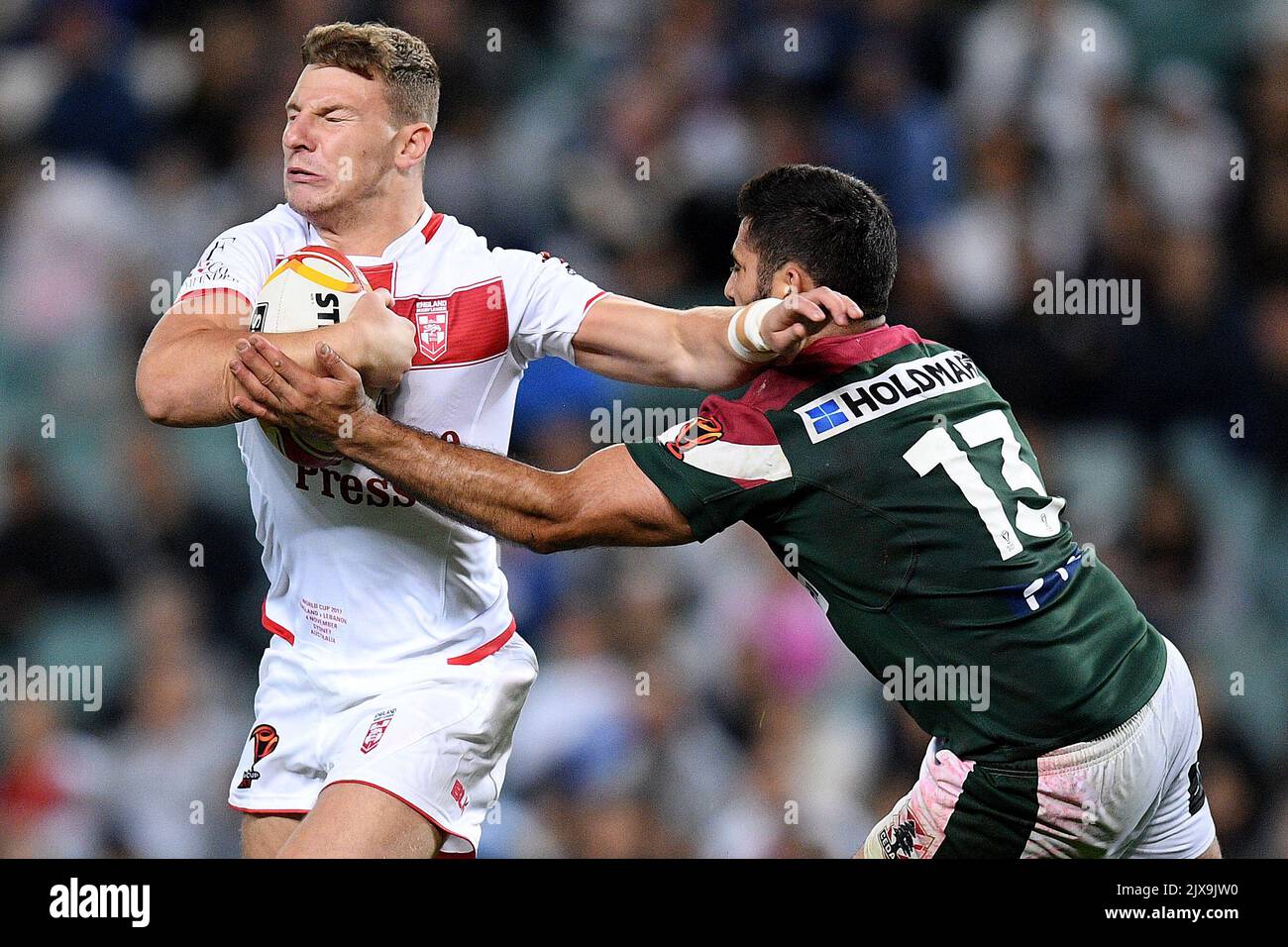 George Williams of England fends off a tackle by Nick Kassis of Lebanon ...