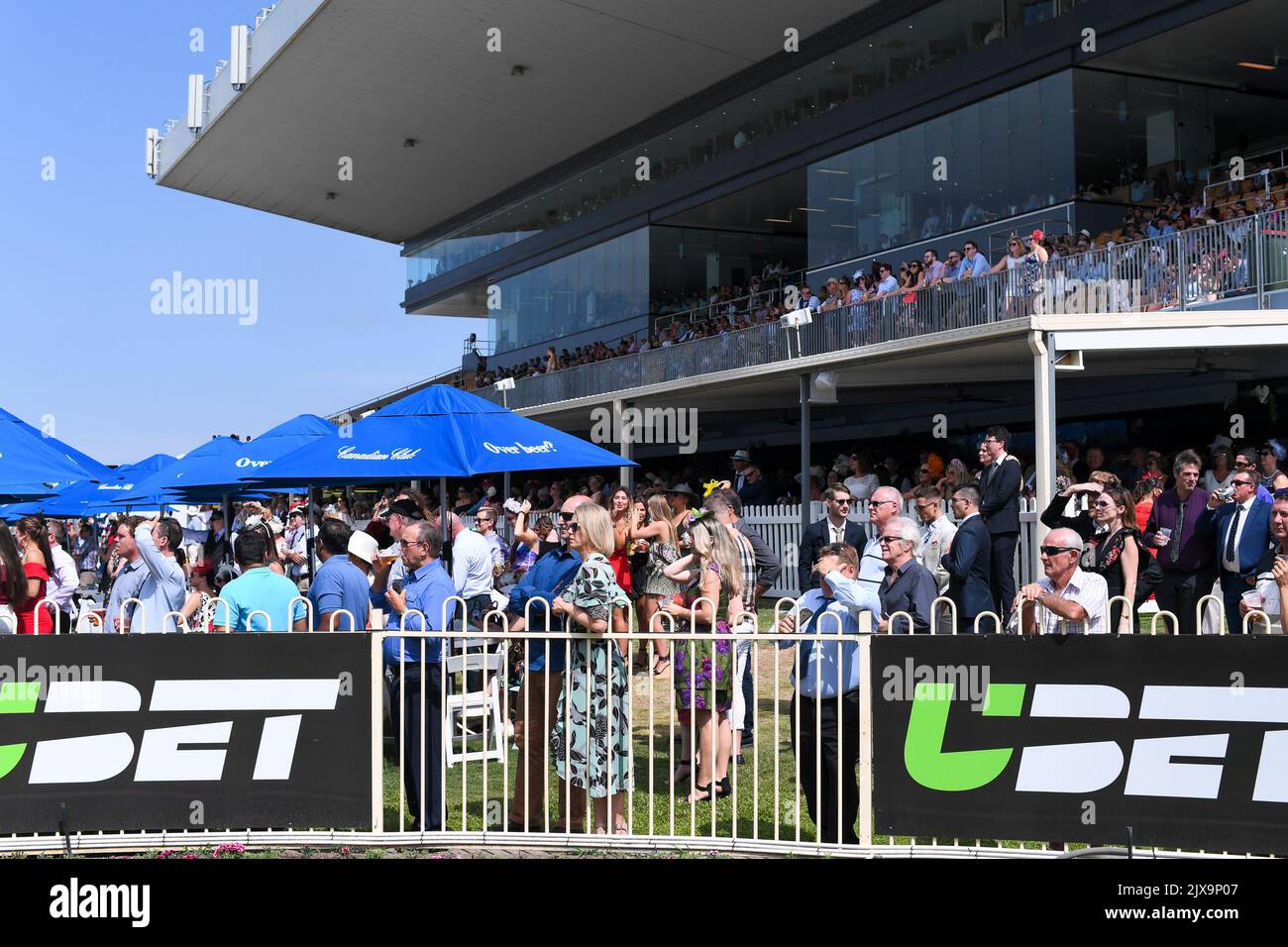 Racegoers watch the Melbourne Cup race at Flemington on screens during ...