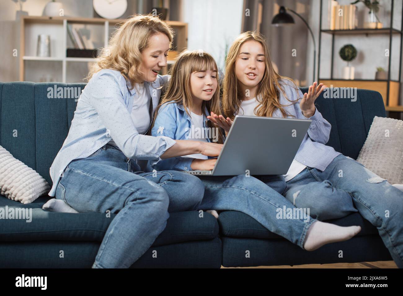 Happy family with two children having good time using laptop. Young ...