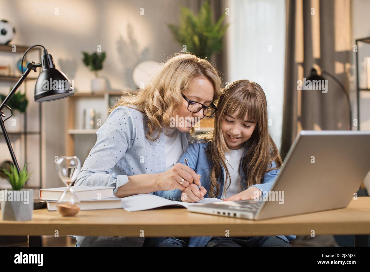 Little kid writing and sketching in notebook, with mother's ...