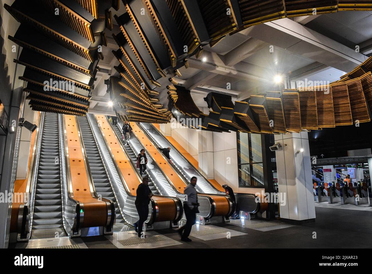 Commuters walk under an installation by artist Chris Fox, titled ...