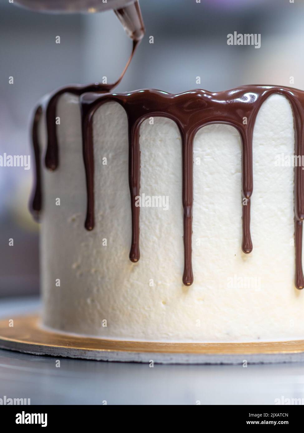 unrecognizable worker preparing a sweet dripping choco cake and berries ...
