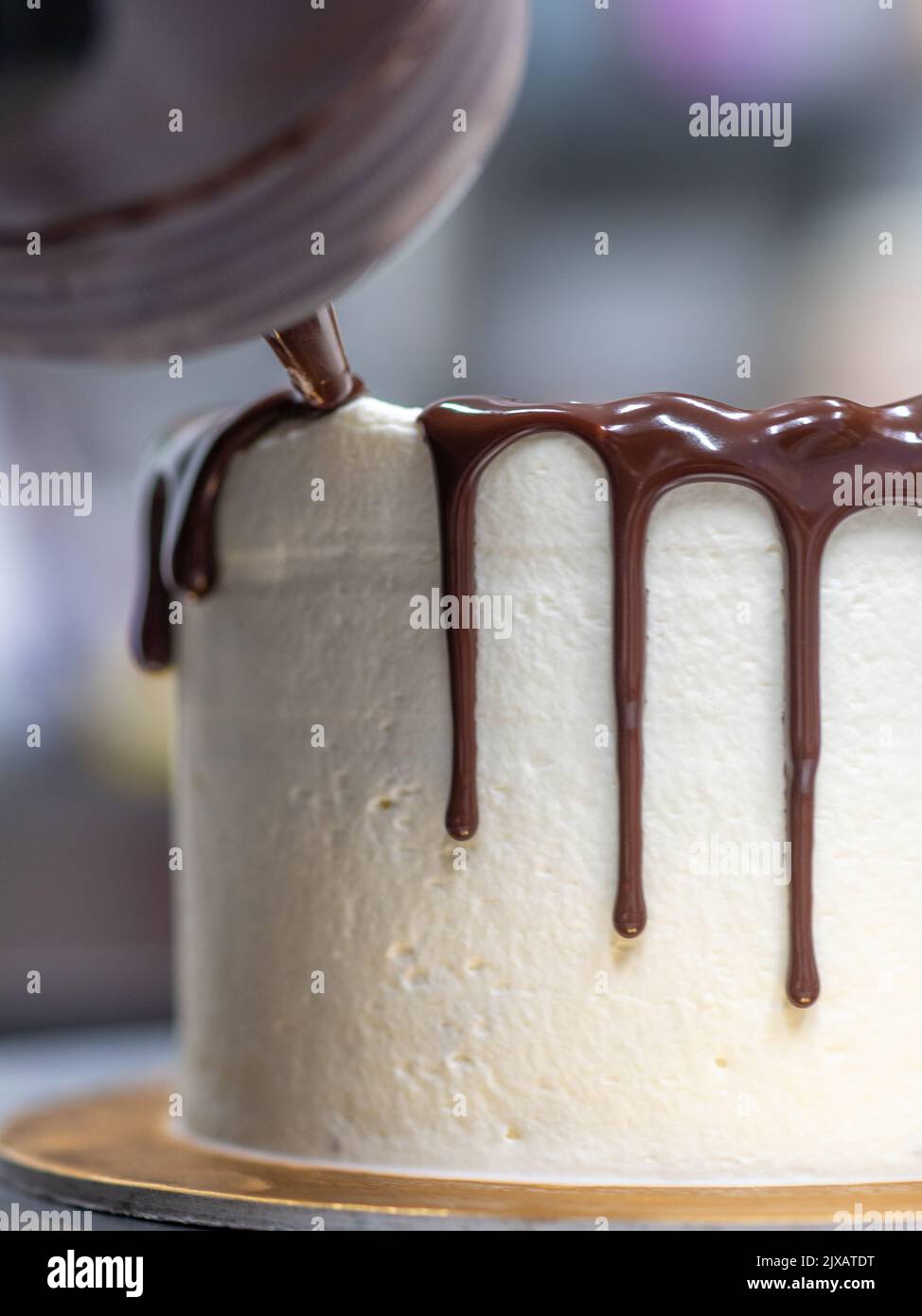 unrecognizable worker preparing a sweet dripping choco cake and berries ...