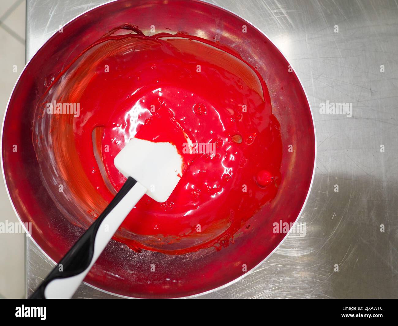 chef making for icing a red drip cake in the professional kitchen lab ...
