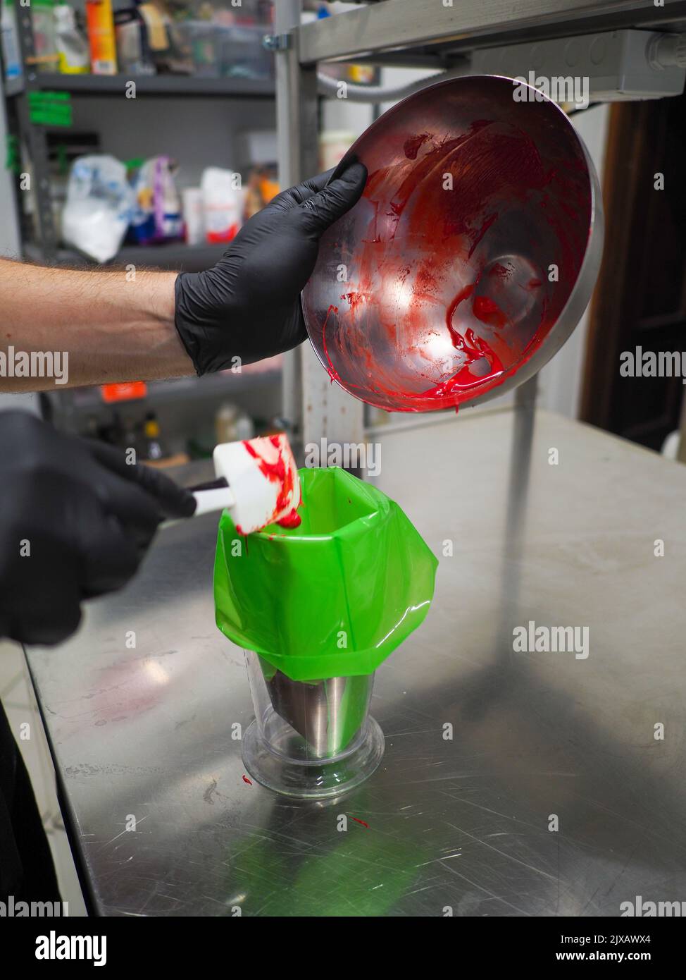 chef making for icing a red drip cake in the professional kitchen lab ...