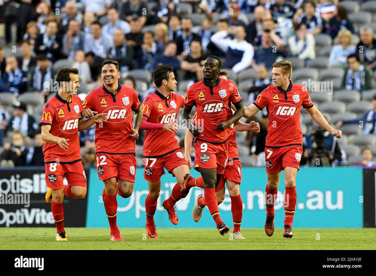 Papa Diawara (centre) of Adelaide celebrates after scoring the side's ...