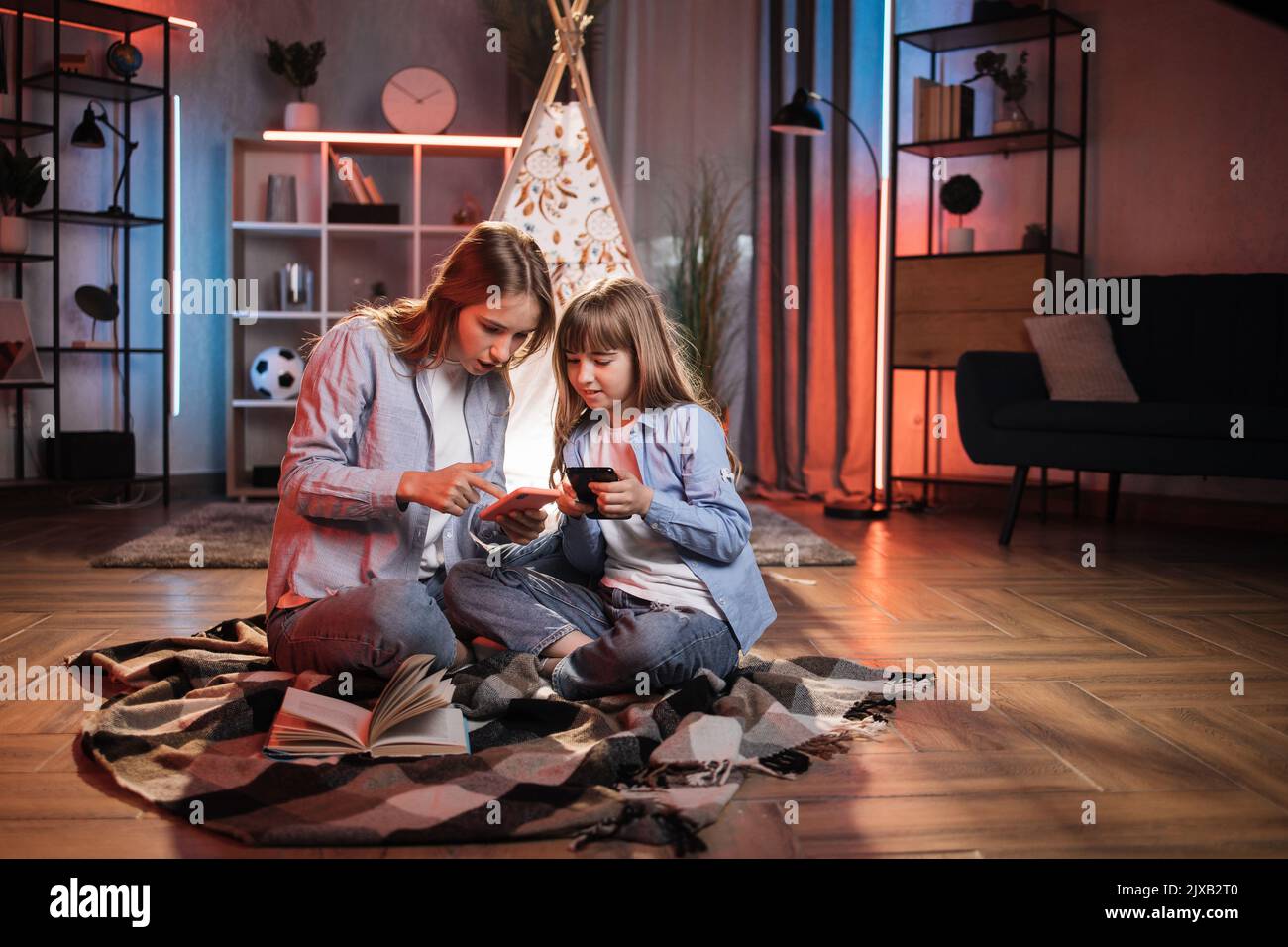 Caring caucasian older sister or nanny with her younger sister outside ...