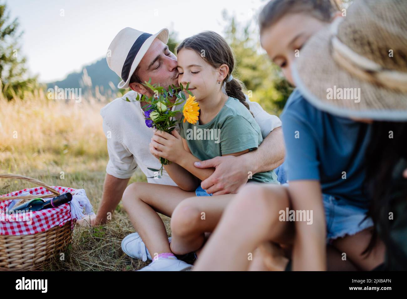 Happy father and his daughter hugging together, celebrating birthday during family picnic in ...
