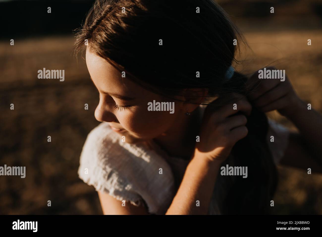 Portrait of a beautiful little girl in summer in nature during sunset ...
