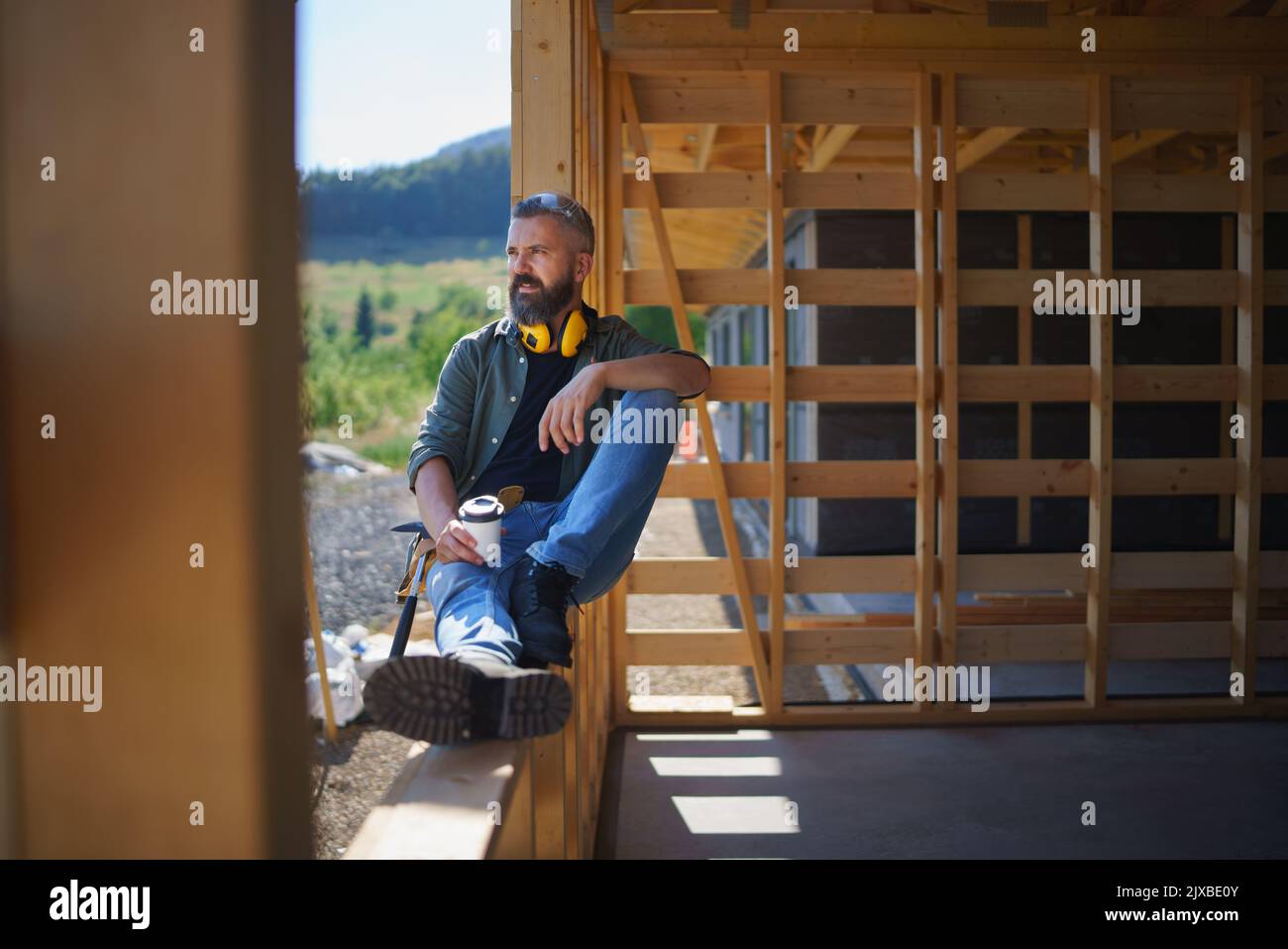 Handyman resting and having break when working on wooden construction ...