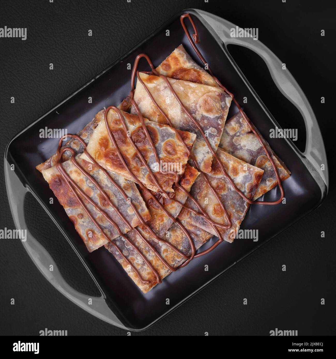 roasted tandoori roti with chocolate arrange in a dish dark background ...