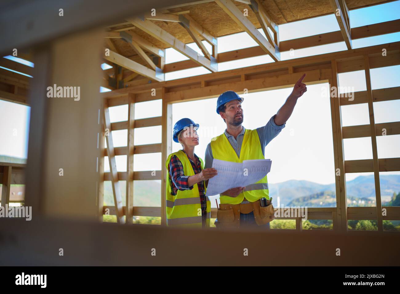 Construction engineers or architects with blueprints visiting and ...