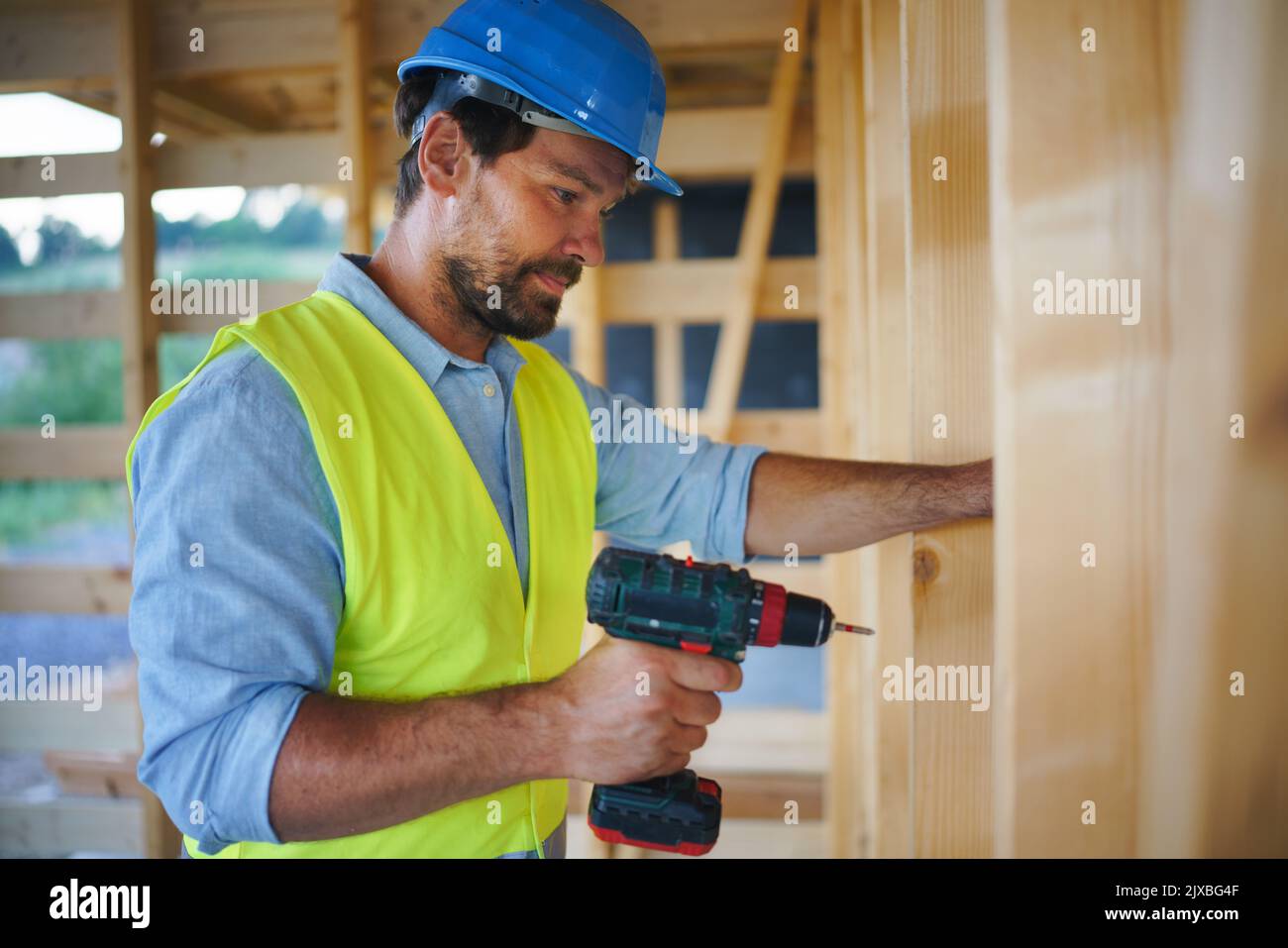 Construction worker working with screwdriver on wooden frame, diy eco ...