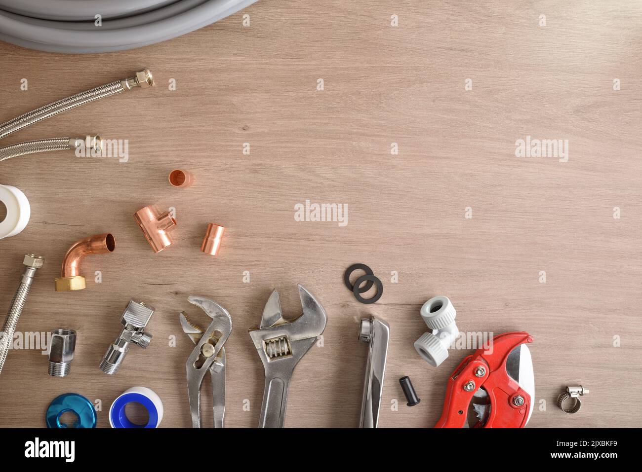 Row of plumbing materials and tools on wooden workbench top view ...