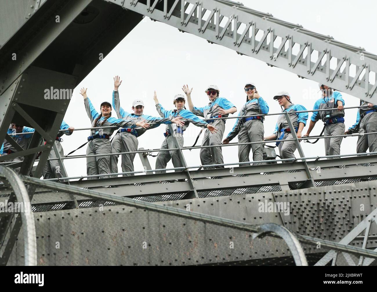 Sightseers wave to the camera as they climb the Story Bridge in ...