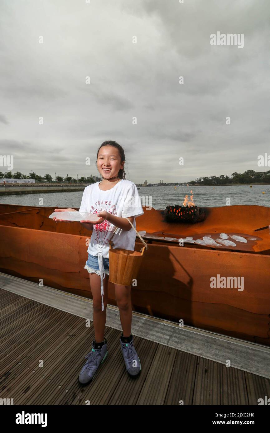 Riana Shimamune poses for a photograph with a frozen fish sculpture, as ...