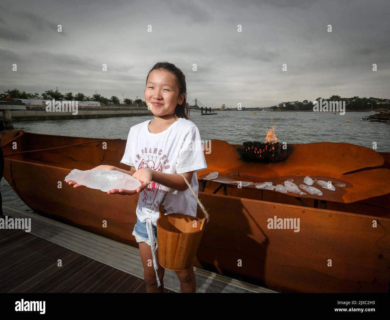 Riana Shimamune poses for a photograph with a frozen fish sculpture, as ...