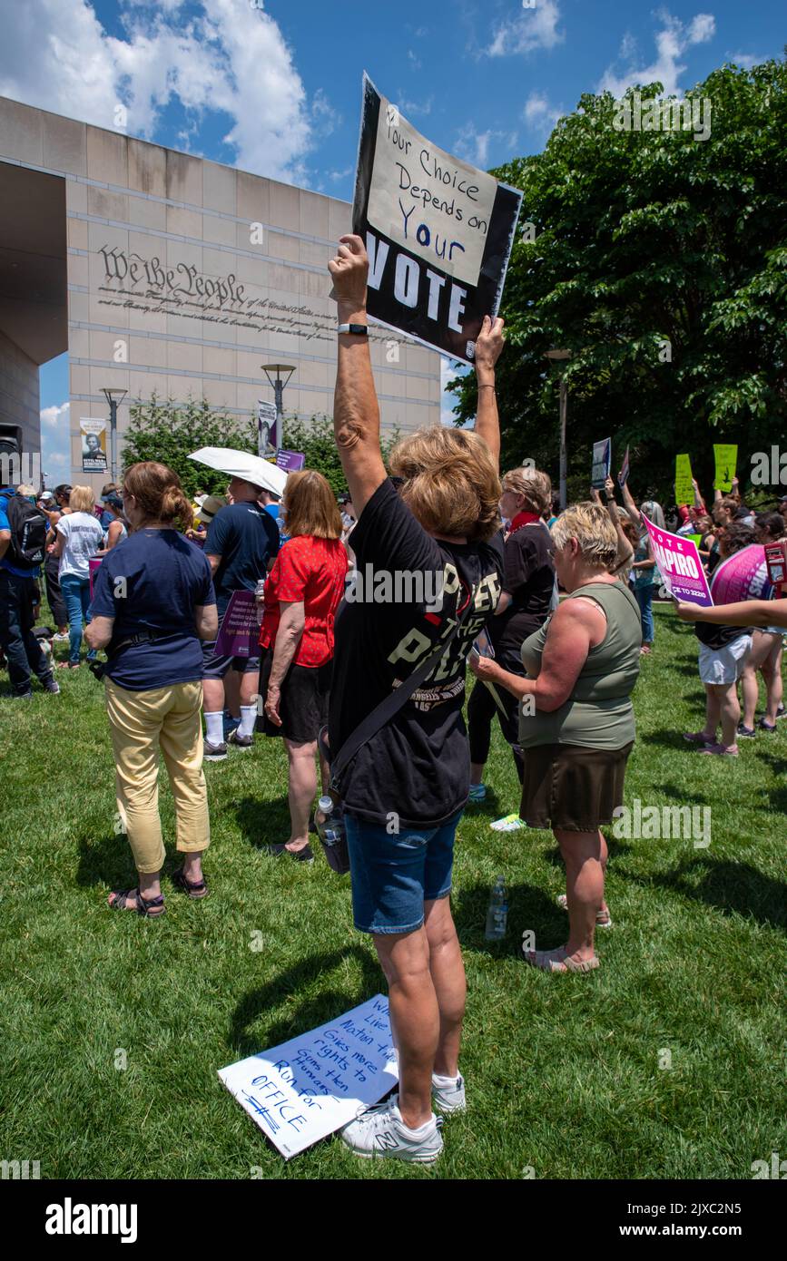 Woman holds a political protest sign at an outdoor pro-choice rally ...