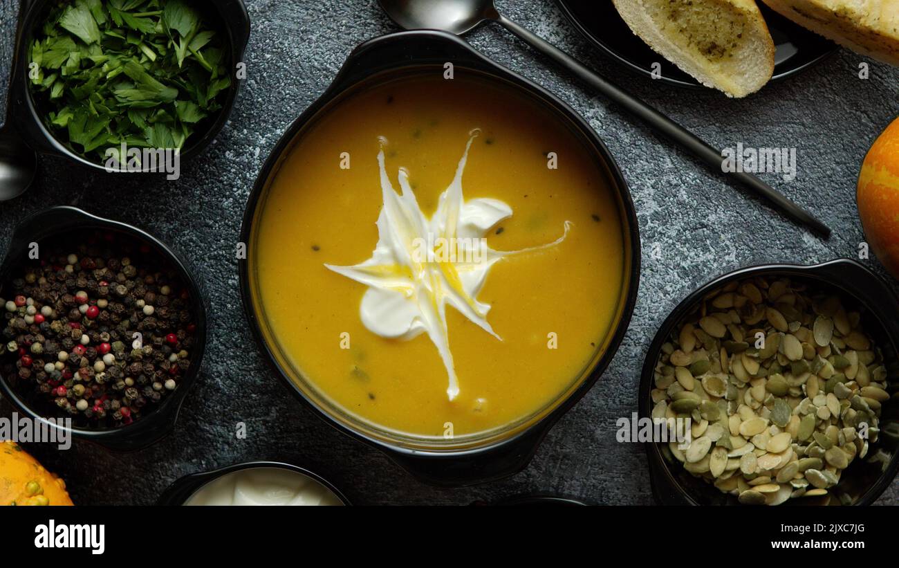 Homemade pumpkin soup with cream and sides. Top view image at stone ...