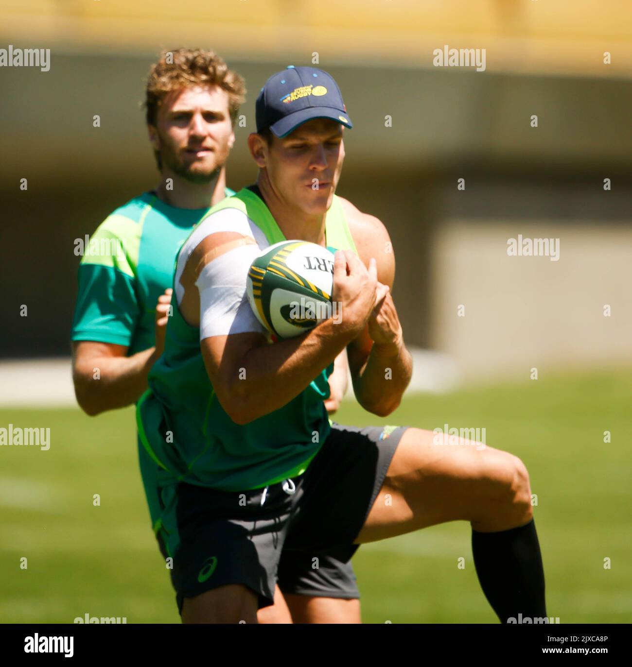 Simon Kennewell (right) runs with the ball during an Australian rugby ...