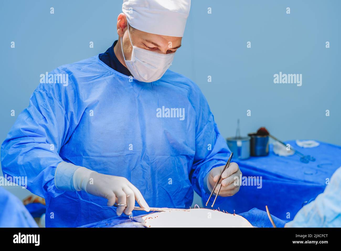 Male surgeon stitches the patient's body during surgery Stock Photo - Alamy