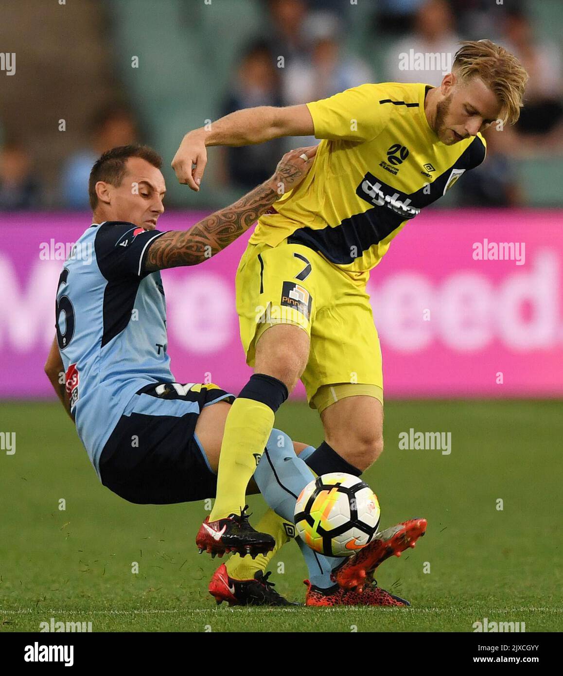 Luke Wilkshire of Sydney tackles Andrew Hoole of the Mariners during ...