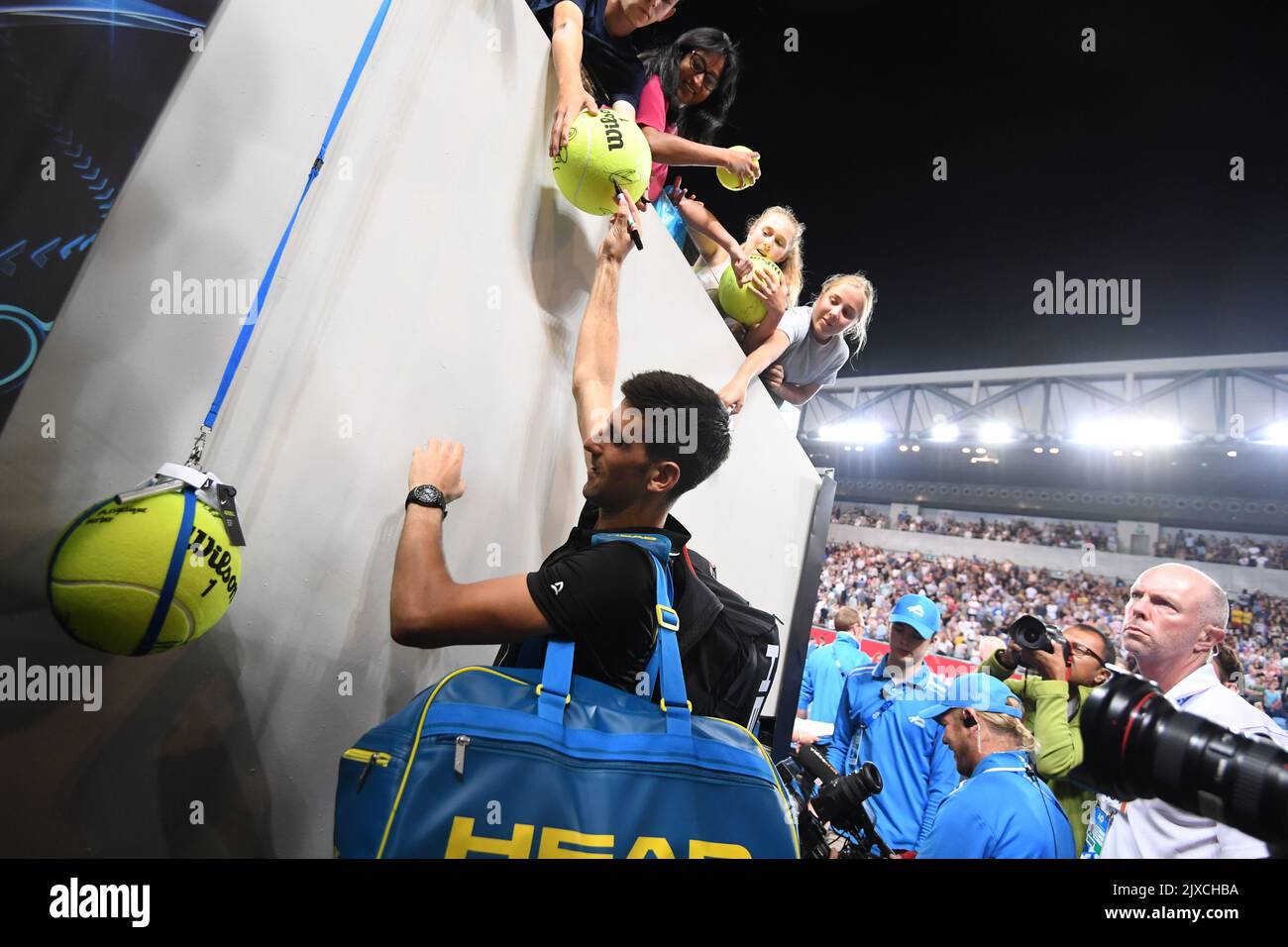 Novak Djokovic of Serbia signs autographs after his win against Albert ...